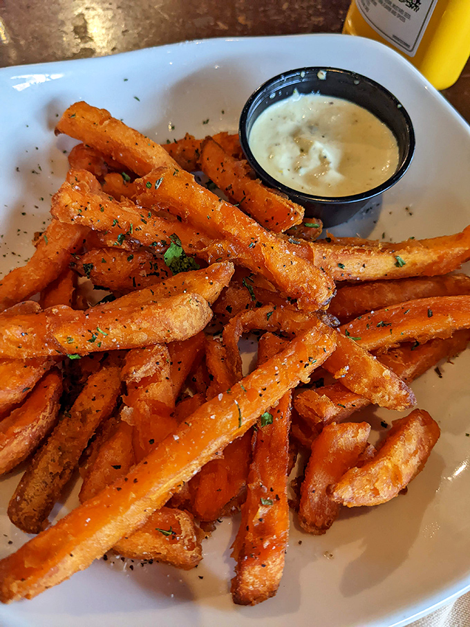 Sweet potato fries that achieve the impossible: crispy exteriors giving way to fluffy interiors. That dipping sauce isn't just an accessory—it's an essential co-star.
