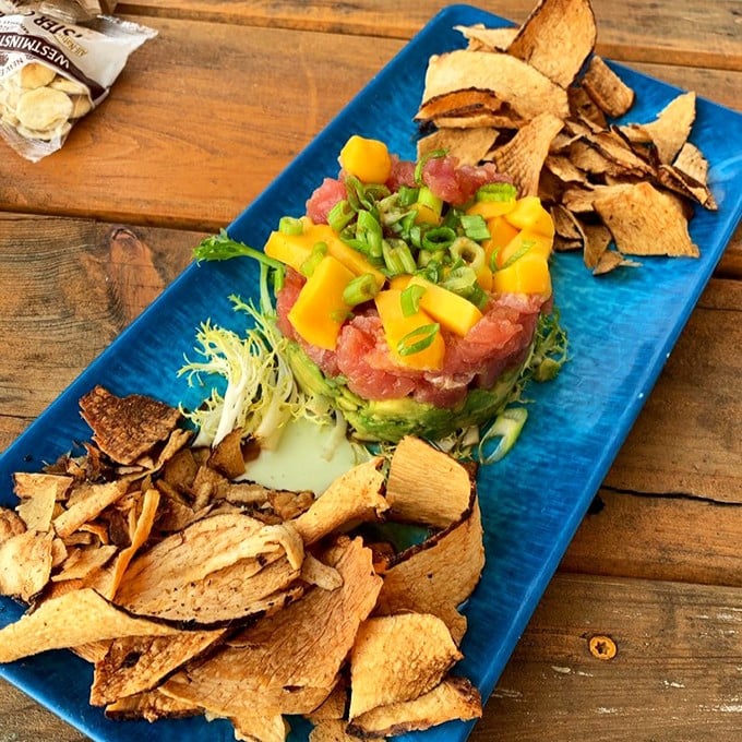 Tuna tartare that's dressed better than most wedding guests—mango, avocado, and crispy tortilla chips create the seafood equivalent of a standing ovation.