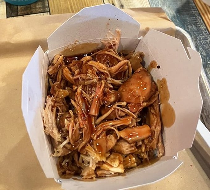 Pulled pork perfection in a box—tender strands of smoky goodness swimming in sauce that would make even the most hardened BBQ critic weep with joy.