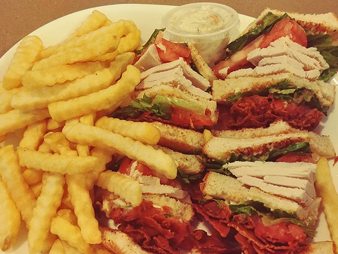 This club sandwich isn't just stacked—it's architected. A skyscraper of turkey, bacon, and fresh veggies that requires a game plan before the first bite.
