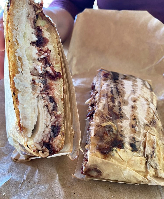 The cross-section tells the story—perfectly grilled bread giving way to layers of savory goodness that makes you wonder why you'd ever eat anything else.