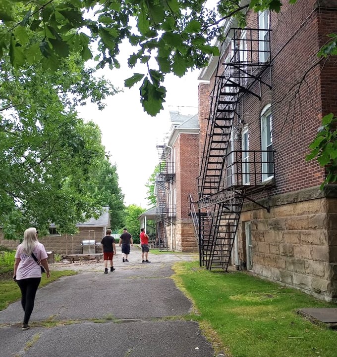 Visitors follow the path alongside iron fire escapes that once offered physical—if not psychological—escape for the building's many inhabitants.