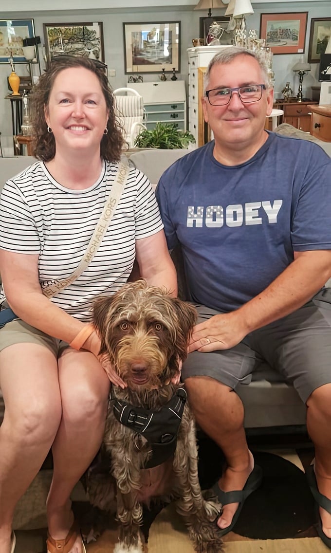Happy shoppers and their four-legged friend celebrate finding the perfect piece—a win-win for everyone involved.