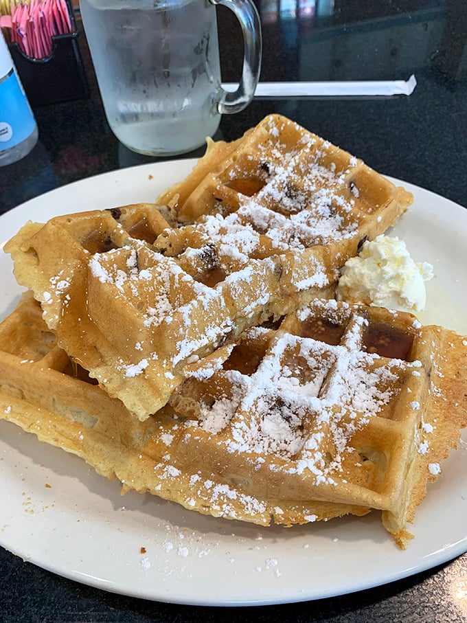 These Belgian waffles aren't just breakfast, they're architecture—deep pockets perfectly engineered to hold powdered sugar and butter in delicious harmony. 
