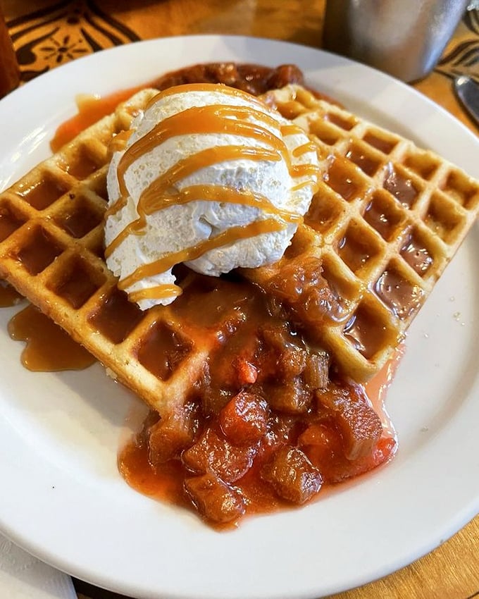 Waffles that have clearly gone to finishing school – perfectly golden, topped with caramelized fruit and whipped cream that's dressed for a special occasion.