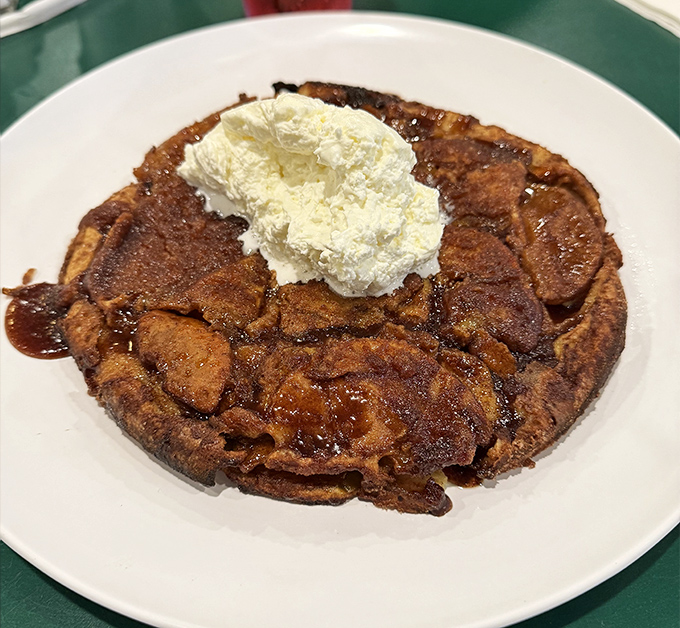 The legendary Apple Pancake arrives like breakfast royalty, crowned with whipped cream and cinnamon-sugar armor. Worth every minute of the 20-minute wait.