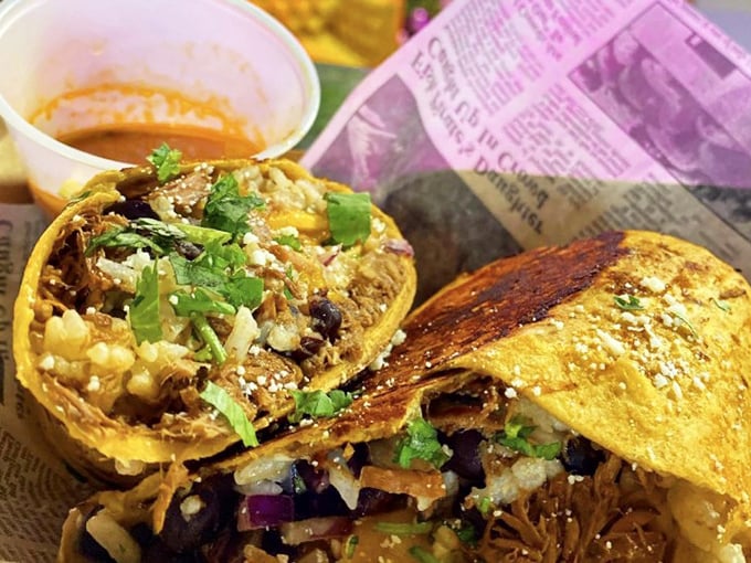 The legendary Birria Burrito in its natural habitat, surrounded by consommé for dunking. This isn't eating—it's a religious experience.