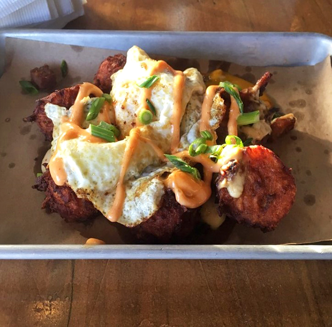 Whoever decided to top crispy tots with eggs and sauce deserves a Nobel Prize in the field of "Things That Make You Happy On A Plate."
