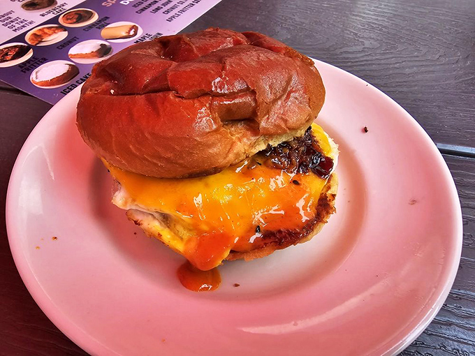 Not just a sandwich but an engineering marvel—melted cheese cascading down a burger nestled in a glossy bun that deserves its own architectural award.