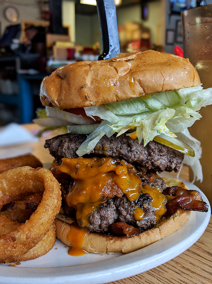 This isn't just a burger—it's a skyscraper of beef, bacon, and cheese with an onion ring moat. Napkins required, regrets impossible.