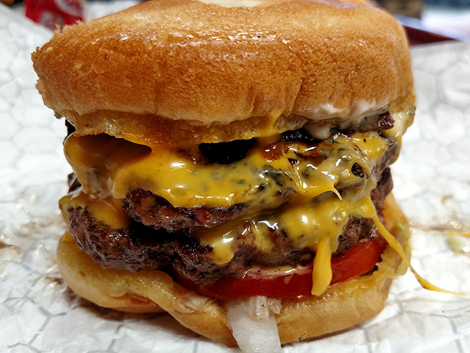 This isn't just a burger—it's a gravity-defying monument to cheese cascading over perfectly seared beef. Napkins: mandatory.
