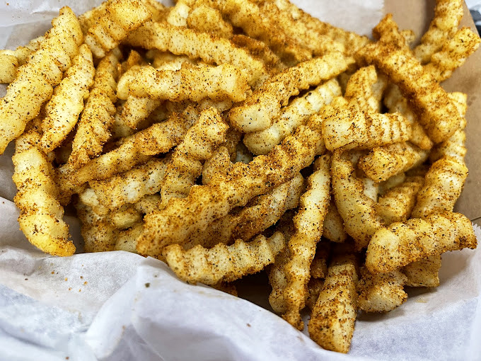 These seasoned crinkle-cut fries arrive dressed to impress – each one wearing its spices like a golden tuxedo.