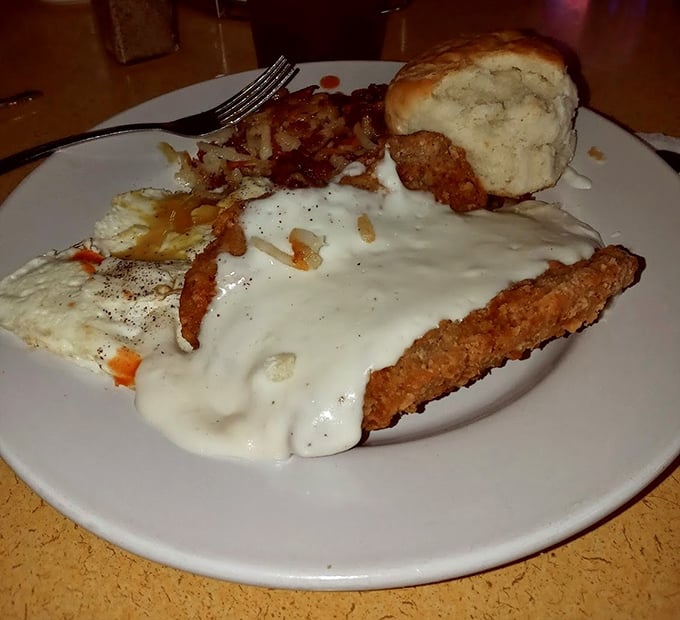 Country fried steak wearing its gravy like a cozy blanket – this is breakfast that means business.