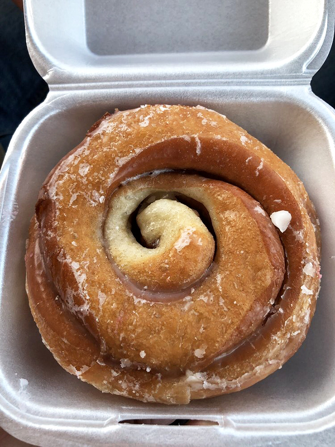 This cinnamon roll isn't just breakfast, it's an event. The perfect spiral suggests it was engineered by someone with a protractor and a sweet tooth.