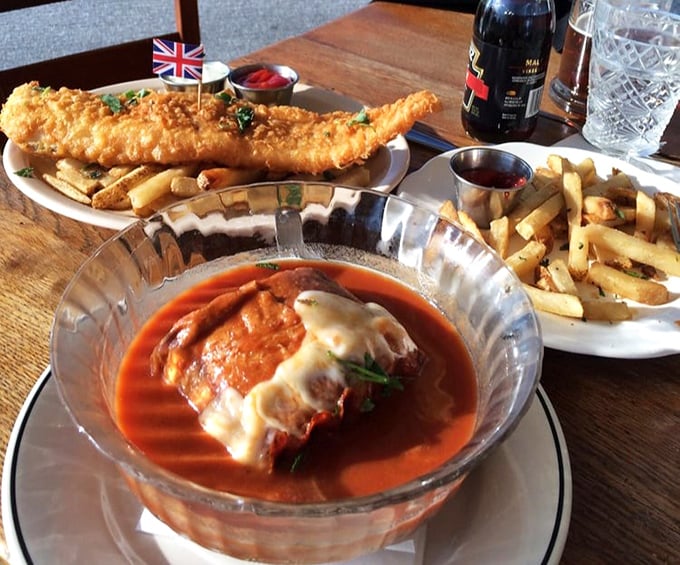 A feast fit for the Queen herself – crispy fish and chips alongside what appears to be eggplant parmesan in tomato sauce, showcasing Payne's impressive range.