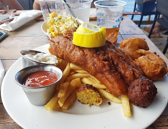 The fish and chips platter arrives like a golden tribute to the sea—crispy, flaky, and ready for its close-up on your Instagram feed.