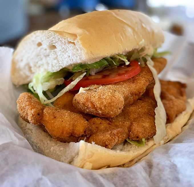 This grouper sandwich isn't just lunch – it's a Florida masterpiece with crispy fish spilling over the bun like it's trying to return to the sea.