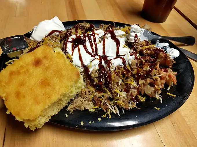This pulled pork plate isn't just dinner—it's edible art. The cornbread sidekick is there to ensure no sauce goes unappreciated.