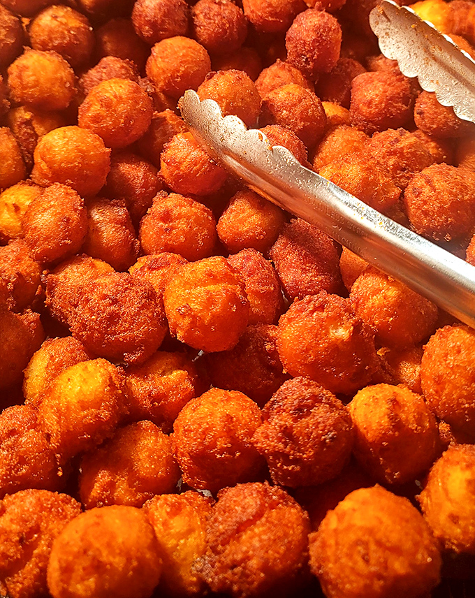 These golden-fried hush puppies aren't just a side dish—they're tiny orbs of cornmeal perfection that could start their own religion.