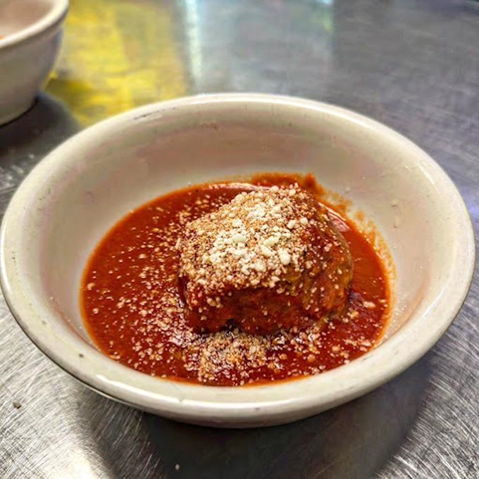 A single meatball swimming in that signature red sauce—like a tiny planet orbiting a delicious sun—waiting to become the center of your universe.