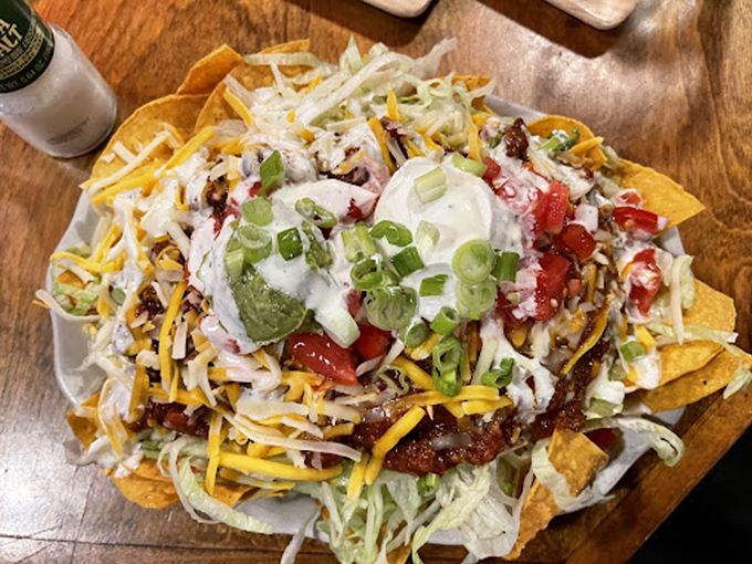 Nachos that require a strategy to eat—like a delicious Jenga tower where every pull reveals another layer of flavor beneath.