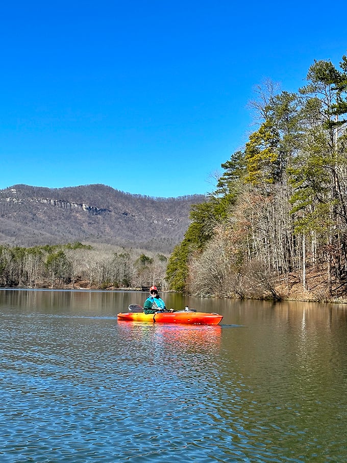 That vibrant kayak isn't just transportation – it's a floating front-row seat to South Carolina's most spectacular mountain theater.