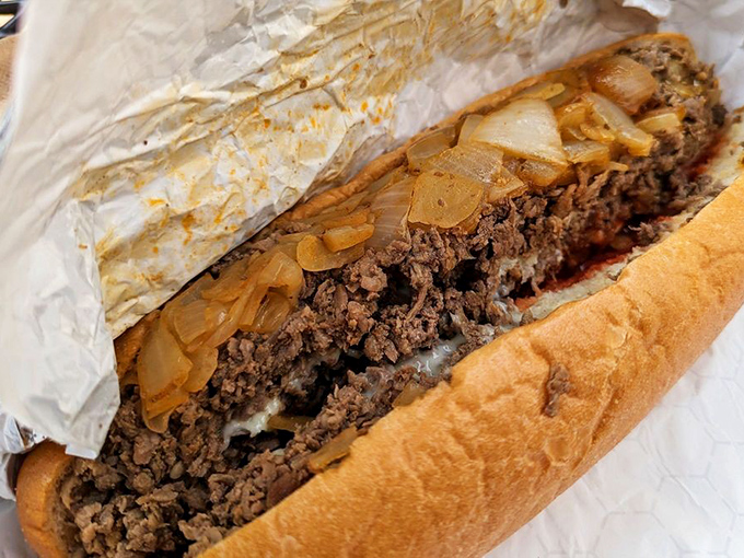 Behold the star of the show! Thinly chopped ribeye and caramelized onions nestled in a perfect roll – this is Philadelphia in sandwich form.