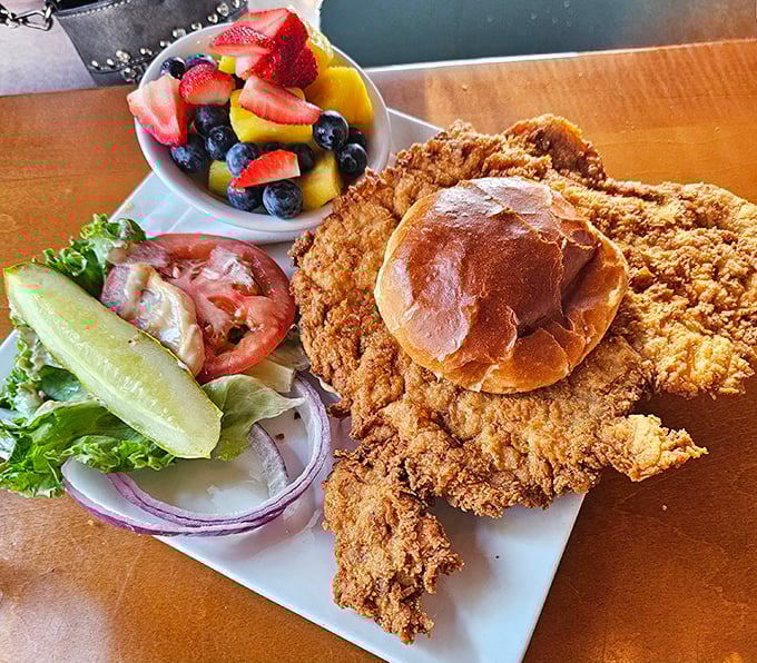 The pork tenderloin—Indiana's unofficial state sandwich—served with fresh fruit that makes you feel slightly virtuous about your indulgence.