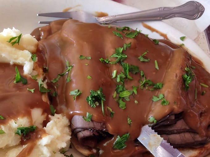 Roast beef so tender it practically surrenders to your fork, swimming in gravy that could make a vegetarian reconsider their life choices.