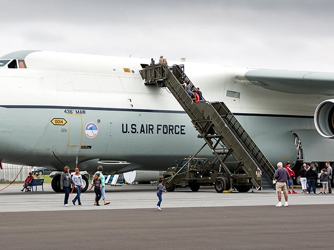 Visitors climbing aboard a military transport aircraft, experiencing what it's like to travel without the complaints about legroom.