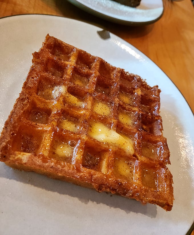This isn't just a waffle, it's architecture with butter. Golden, crisp exterior hiding pockets of warm, custardy interior—breakfast elevated to art form.