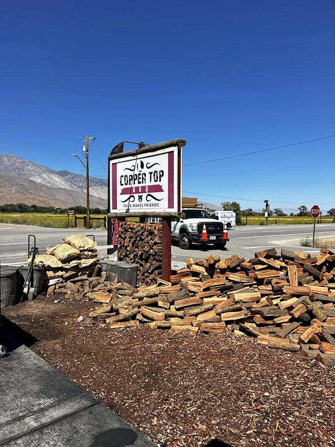 Copper Top BBQ's sign stands tall against the Eastern Sierra backdrop. Mountain air makes everything taste better, especially smoked meat.