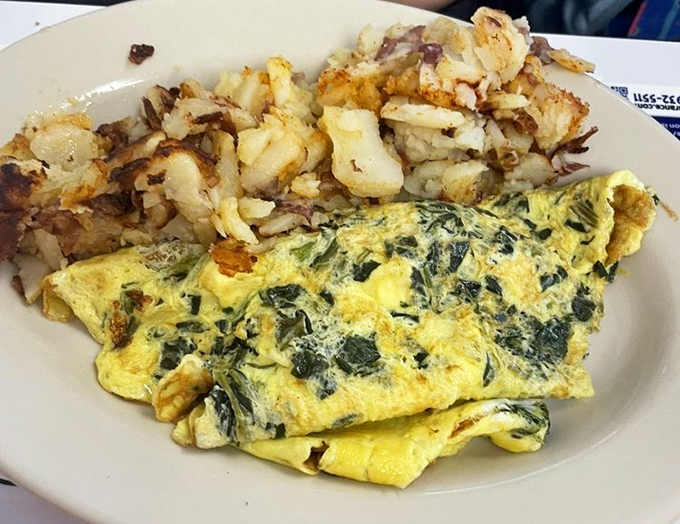 This isn't just an omelet—it's a masterpiece of morning engineering with vegetables folded into fluffy eggs alongside crispy potatoes.