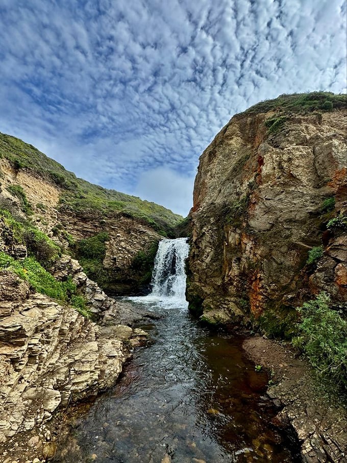 Hidden between coastal cliffs, this upper cascade is the appetizer before the main course – a preview of watery wonders to come.