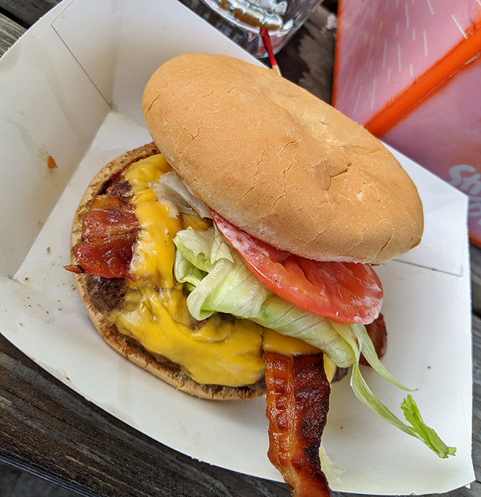Behold the bacon cheeseburger in its natural habitat—simple, unpretentious, and absolutely magnificent. No filter needed for this beauty.