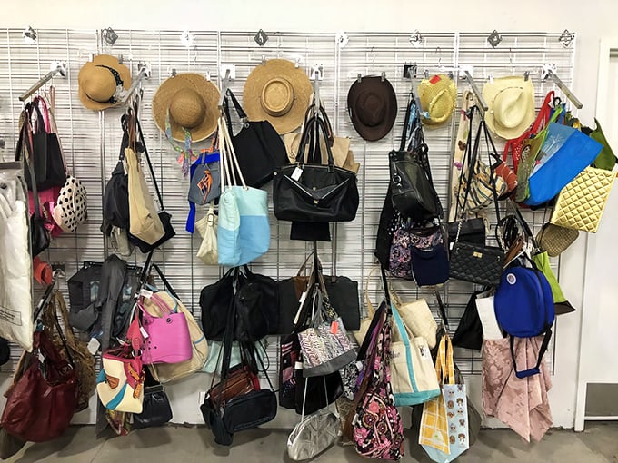 The accessories wall—where Florida sun hats and designer handbags coexist in perfect secondhand harmony.