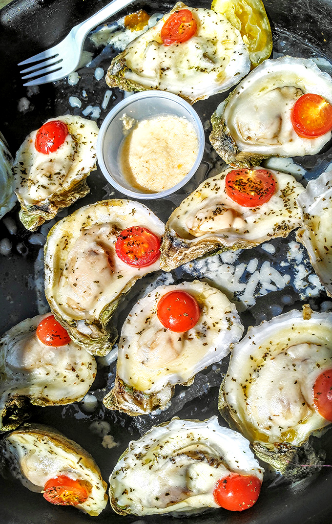 These baked oysters topped with cherry tomatoes aren't just seafood—they're little works of art that taste even better than they look.