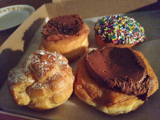 A quartet of donuts showing off their personalities: powdered, chocolate-topped, sprinkled, and cream-filled—the Fab Four of the pastry world.