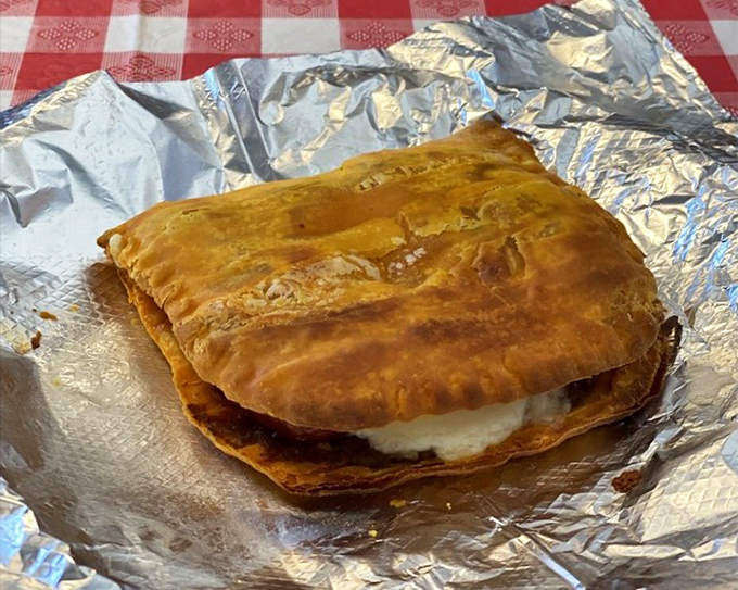 This calzone isn't playing around – it's the heavyweight champion of hand-held Italian delights, with a side of marinara for good measure. 