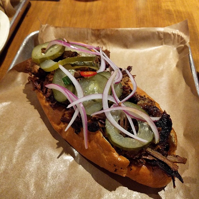 A sandwich that requires commitment and possibly a signed waiver. Those pickled red onions cut through the richness like witty banter.