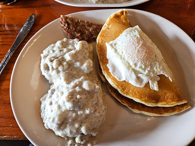 Biscuits smothered in country gravy alongside golden pancakes. The kind of plate that makes you want to call your cardiologist just to brag.