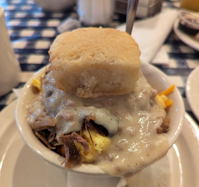 Not just biscuits and gravy—it's a Southern baptism by cream sauce with a biscuit hat perched atop like a delicious crown.