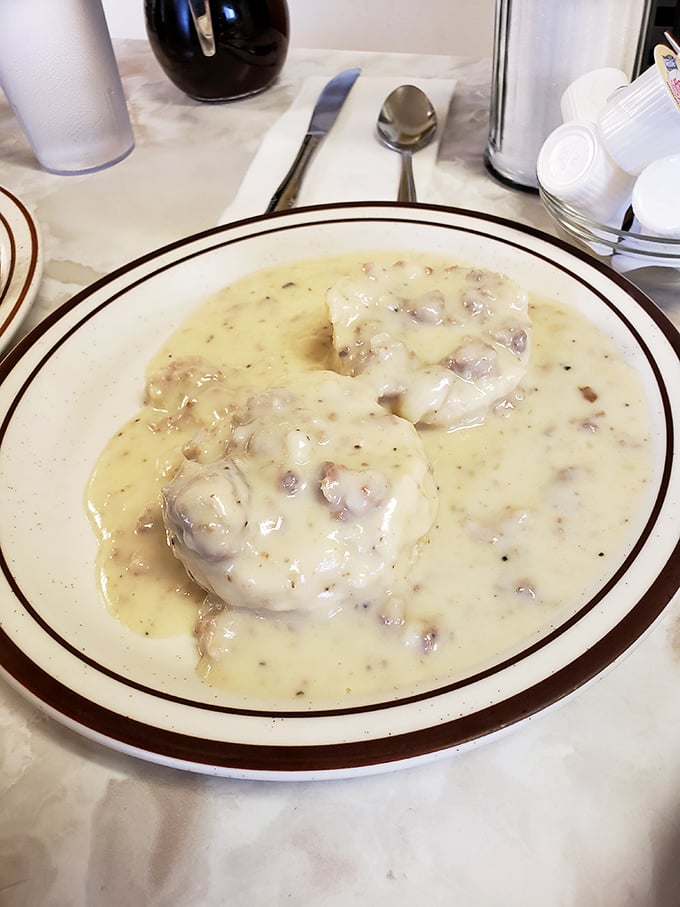 The legendary biscuits and gravy—two golden islands floating in a sea of sausage-studded gravy that's worth every single calorie.