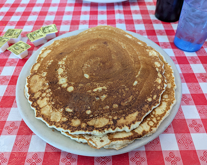 Pancakes the size of hubcaps—golden, fluffy, and ready to soak up maple syrup like they're being paid to do it.