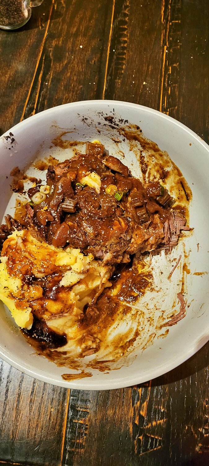 Braised short rib so tender it practically surrenders to your fork, nestled alongside mashed potatoes that could make a carb-counter reconsider their life choices.
