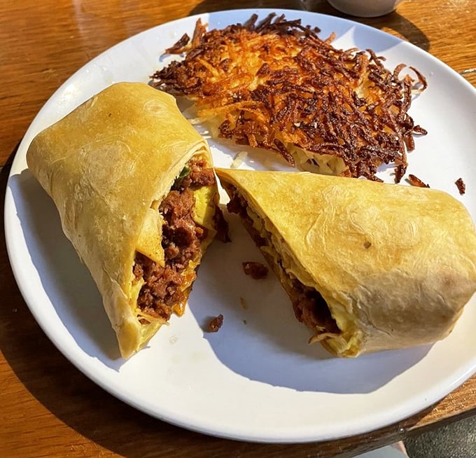 The breakfast burrito—where morning ingredients gather for a flavor party wrapped in a tortilla blanket, with crispy hash browns standing guard.