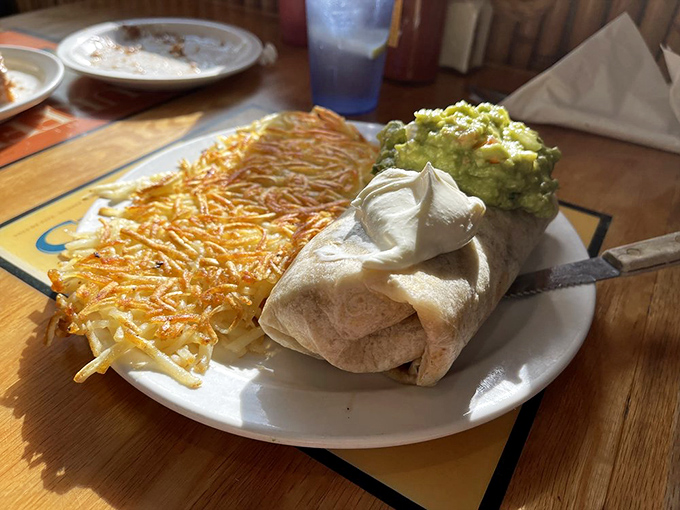 Breakfast burritos should always be this photogenic—crispy hash browns, fresh guacamole, and a tortilla wrapped tighter than your vacation budget.