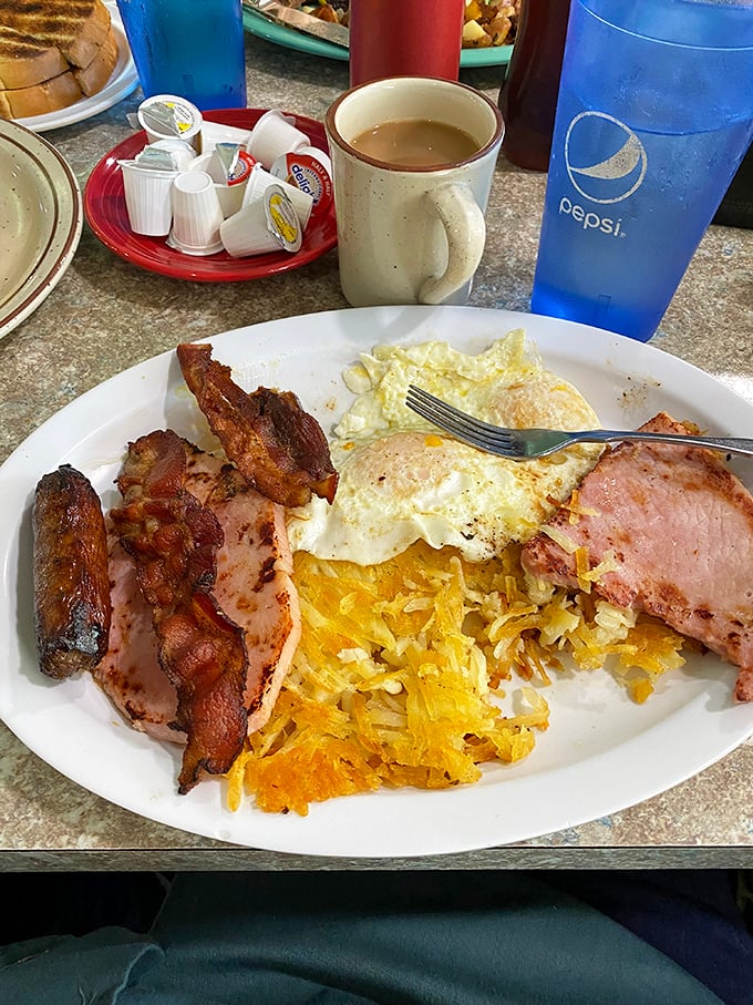 The breakfast trinity: perfectly cooked eggs, hash browns with the ideal crisp-to-tender ratio, and meat that makes you grateful for morning hunger.