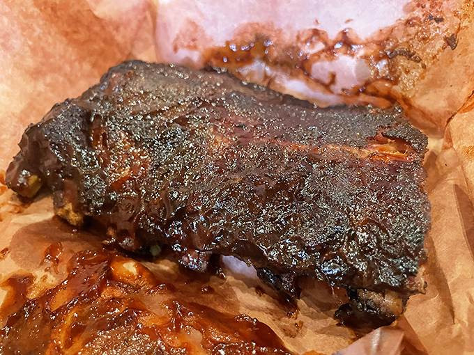 The brisket's bark is like nature's candy—a peppery, smoky crust protecting meat so tender it practically surrenders at the sight of a fork.