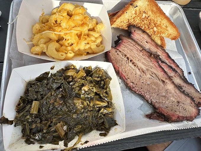 A tray of brisket, collard greens, and mac and cheese—the holy trinity of Southern comfort that speaks directly to your soul.